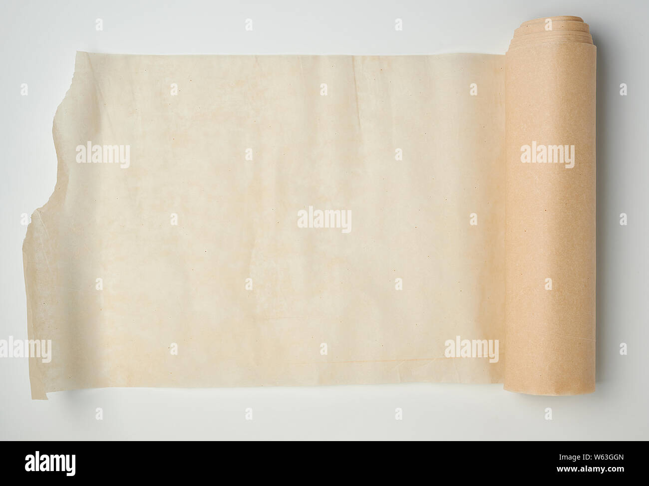 light brown roll with parchment paper spun on a white background, copy ...
