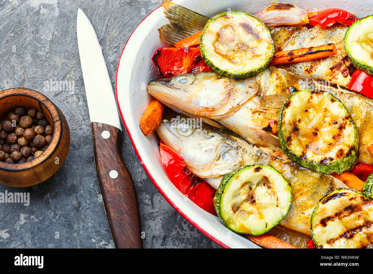 Baked fish with vegetable garnish.Baked pike perch with zucchini and ...