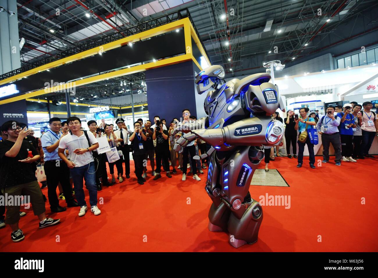 Chinese visitors view or take pictures of an intelligent robot of ...
