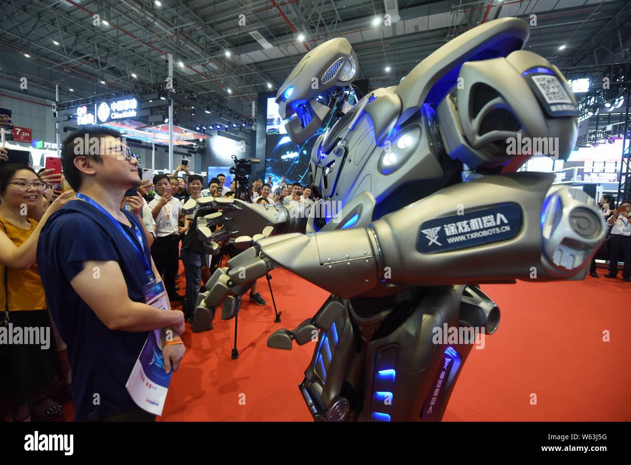 Chinese visitors view or take pictures of an intelligent robot of ...