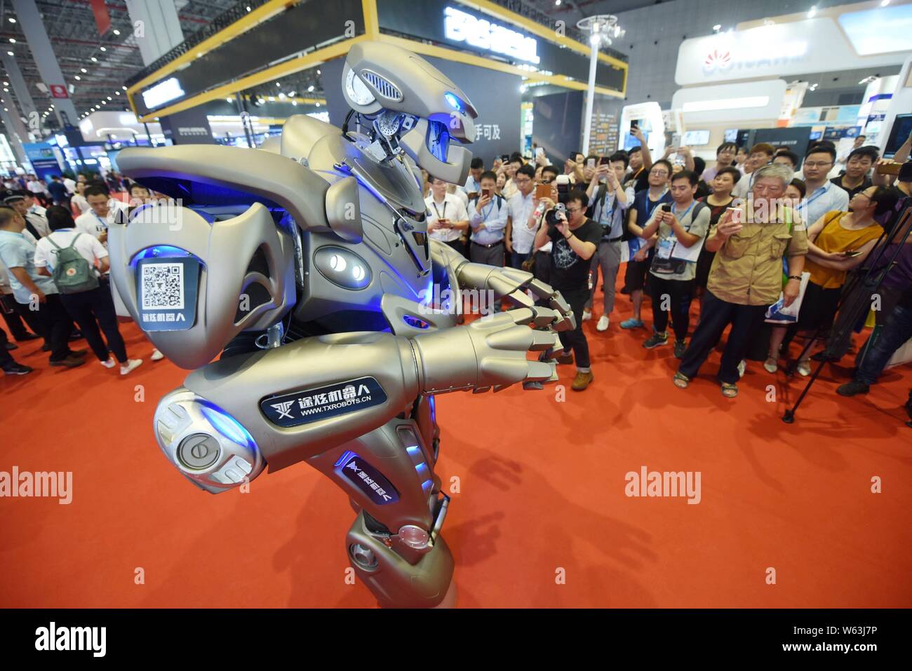Chinese visitors view or take pictures of an intelligent robot of ...