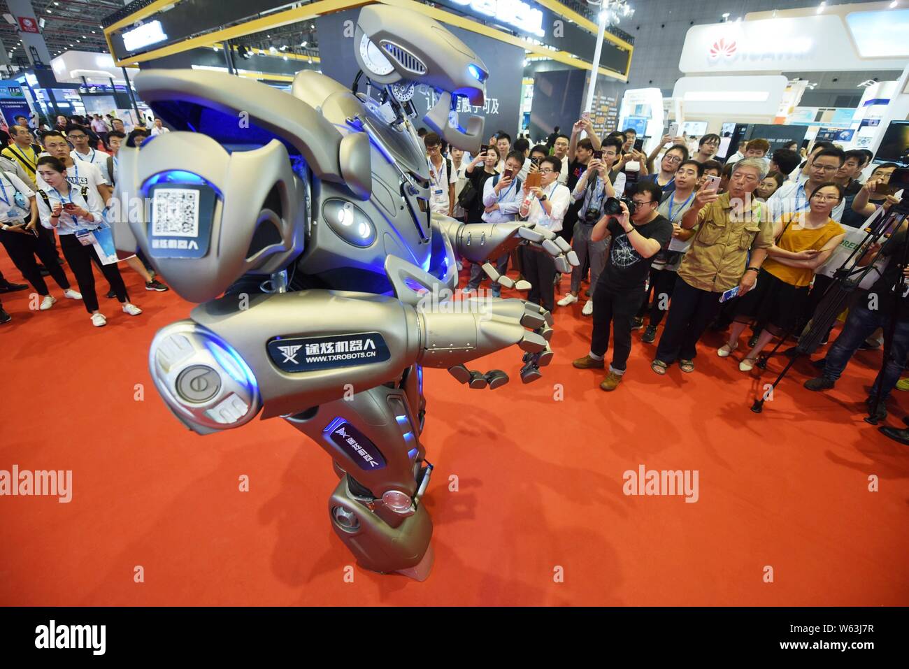Chinese visitors view or take pictures of an intelligent robot of ...