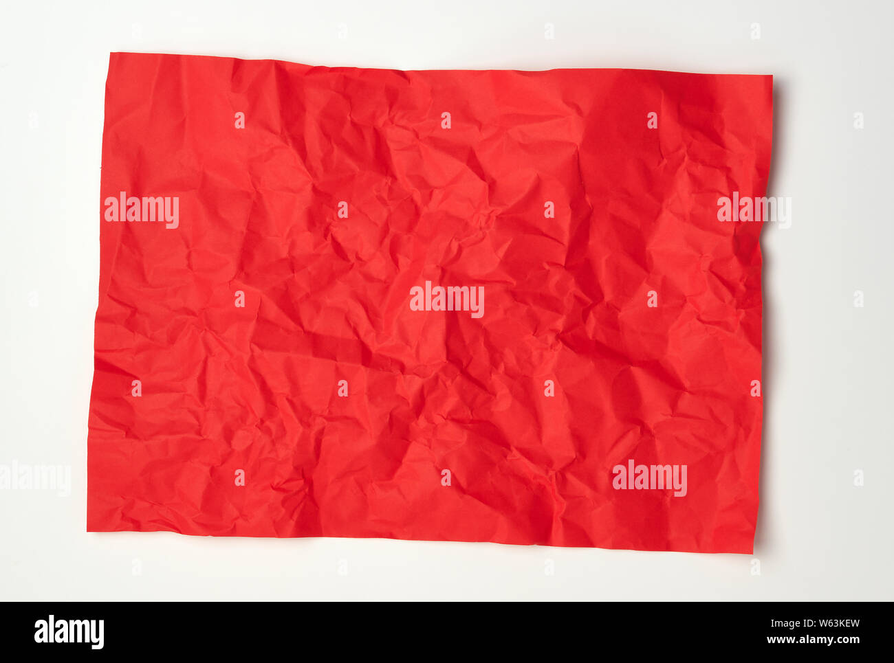 crumpled red rectangular sheet of paper on a white background, copy ...