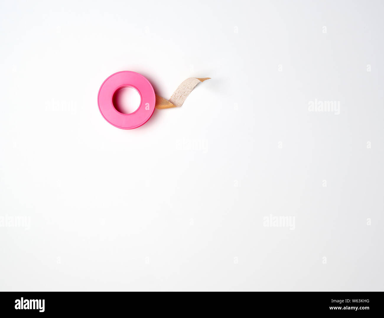 medical textile adhesive plaster for skin in a twisted, pink plastic ...