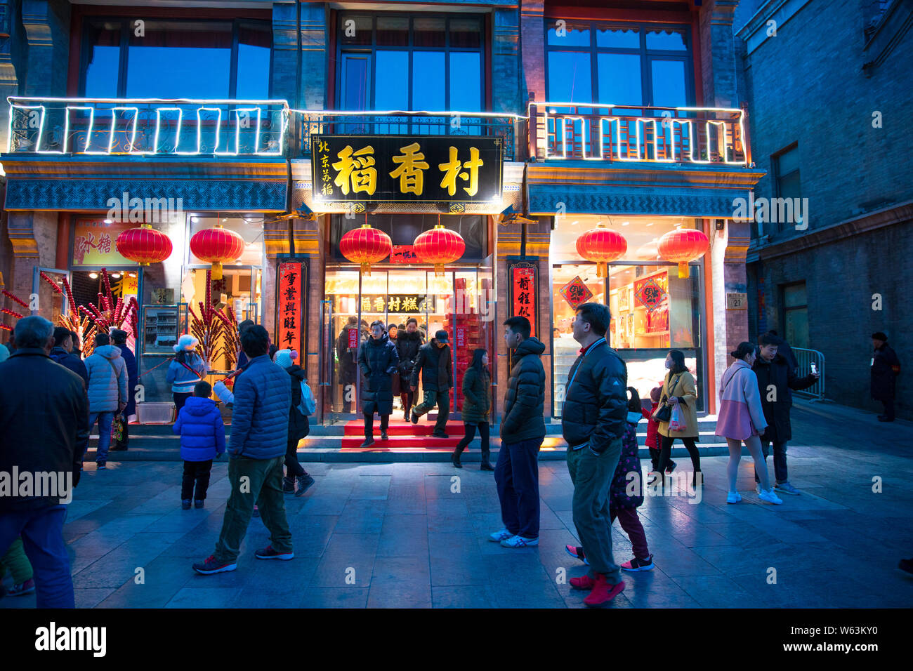 --FILE--Chinese pedestrians walk past a store of traditional Chinese ...