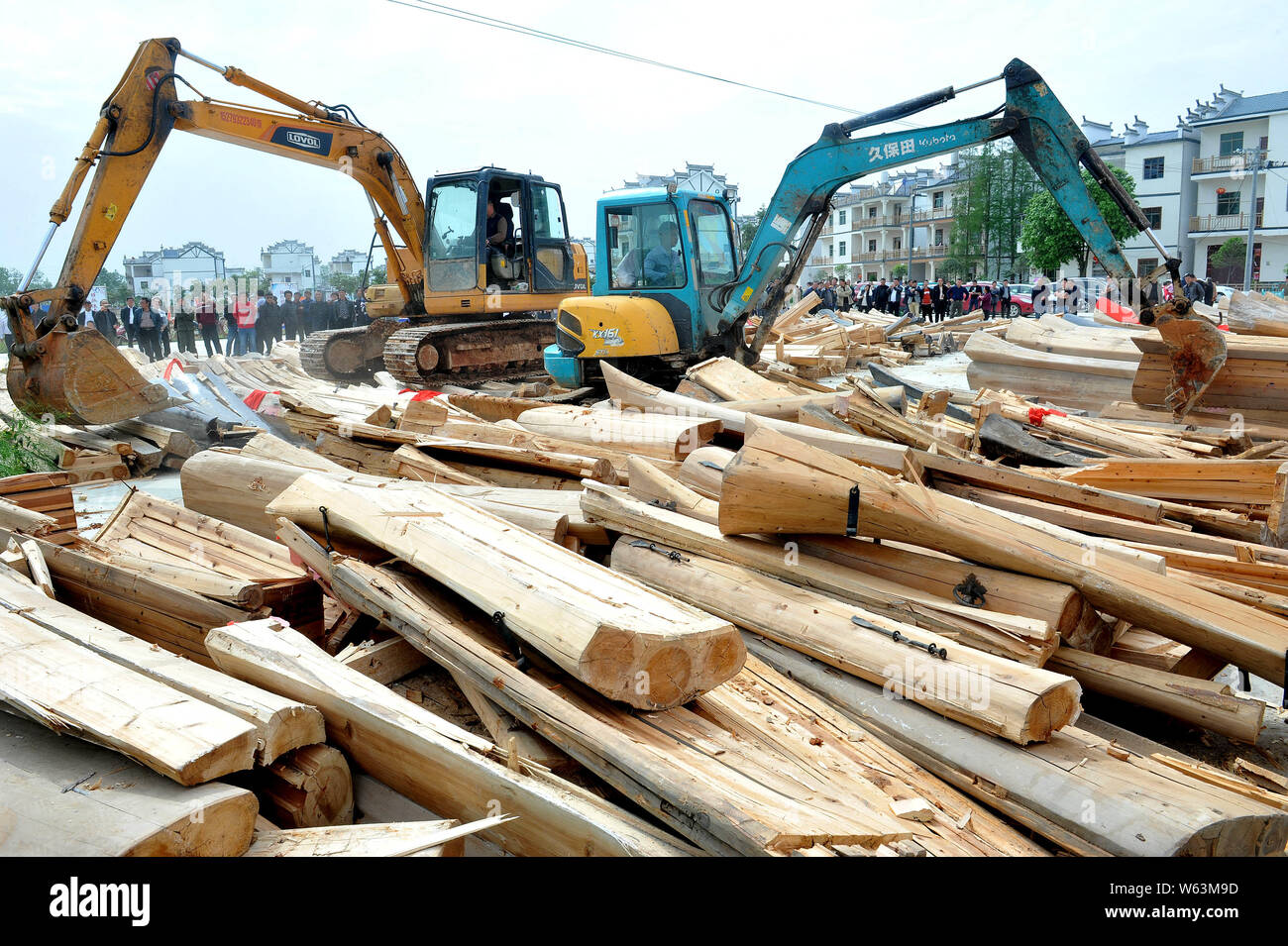 --FILE--Chinese workers operate excavators to crush coffins handed over ...