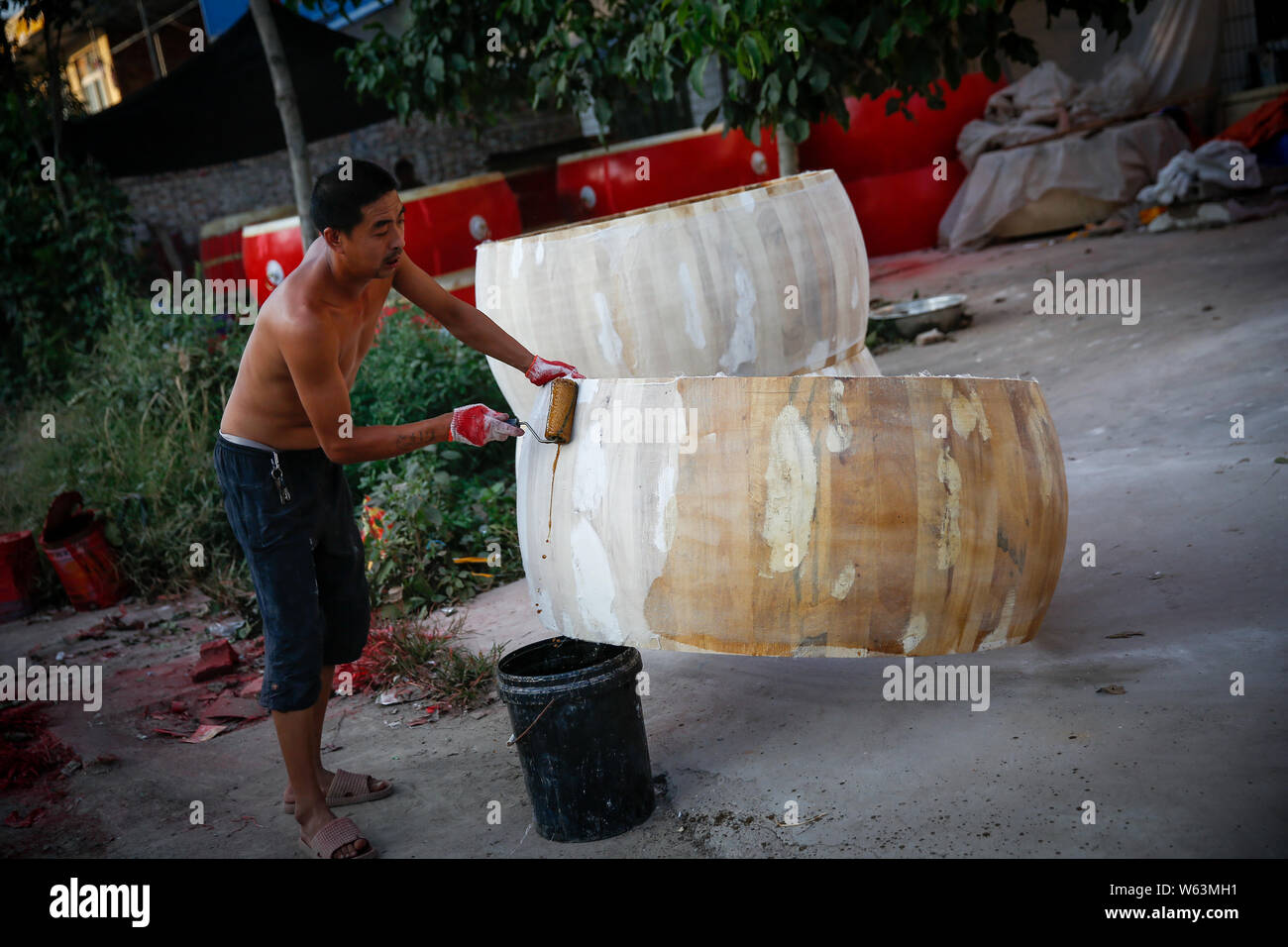 A villager makes a traditional Chinese drum at the Matun village ...