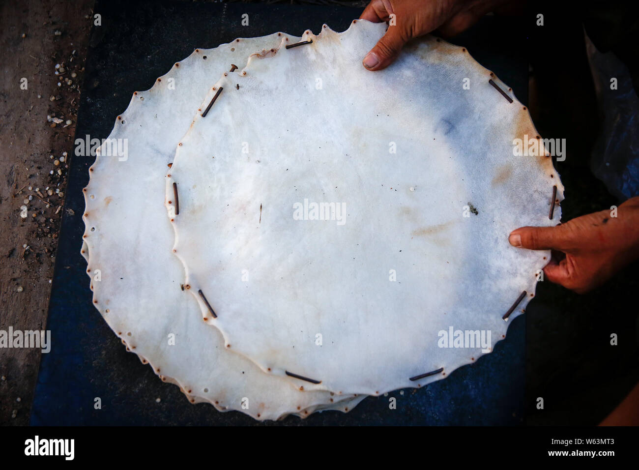 A villager makes a traditional Chinese drum at the Matun village ...