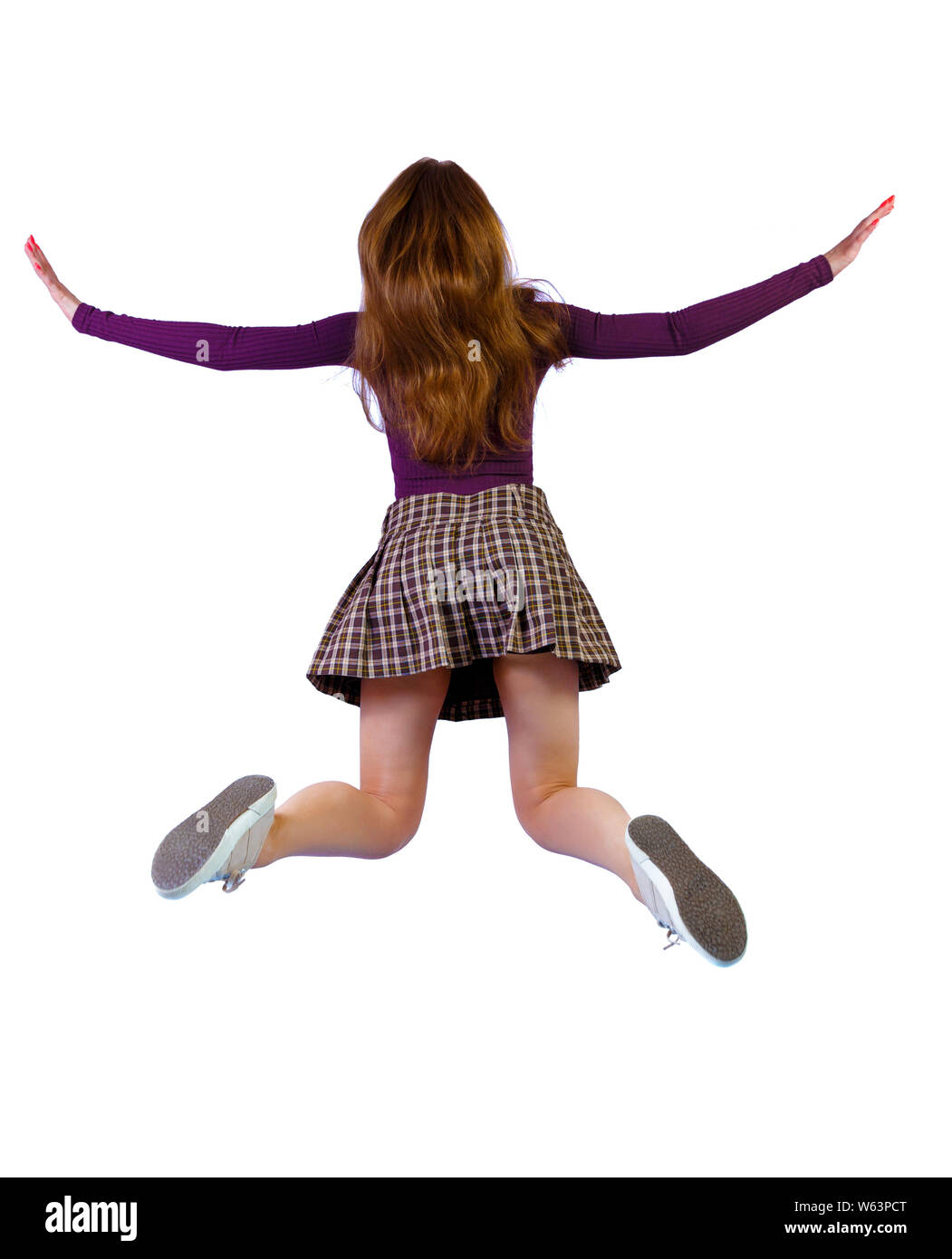 Back view of girl in a jump. Red-haired girl jumps. back side view of ...