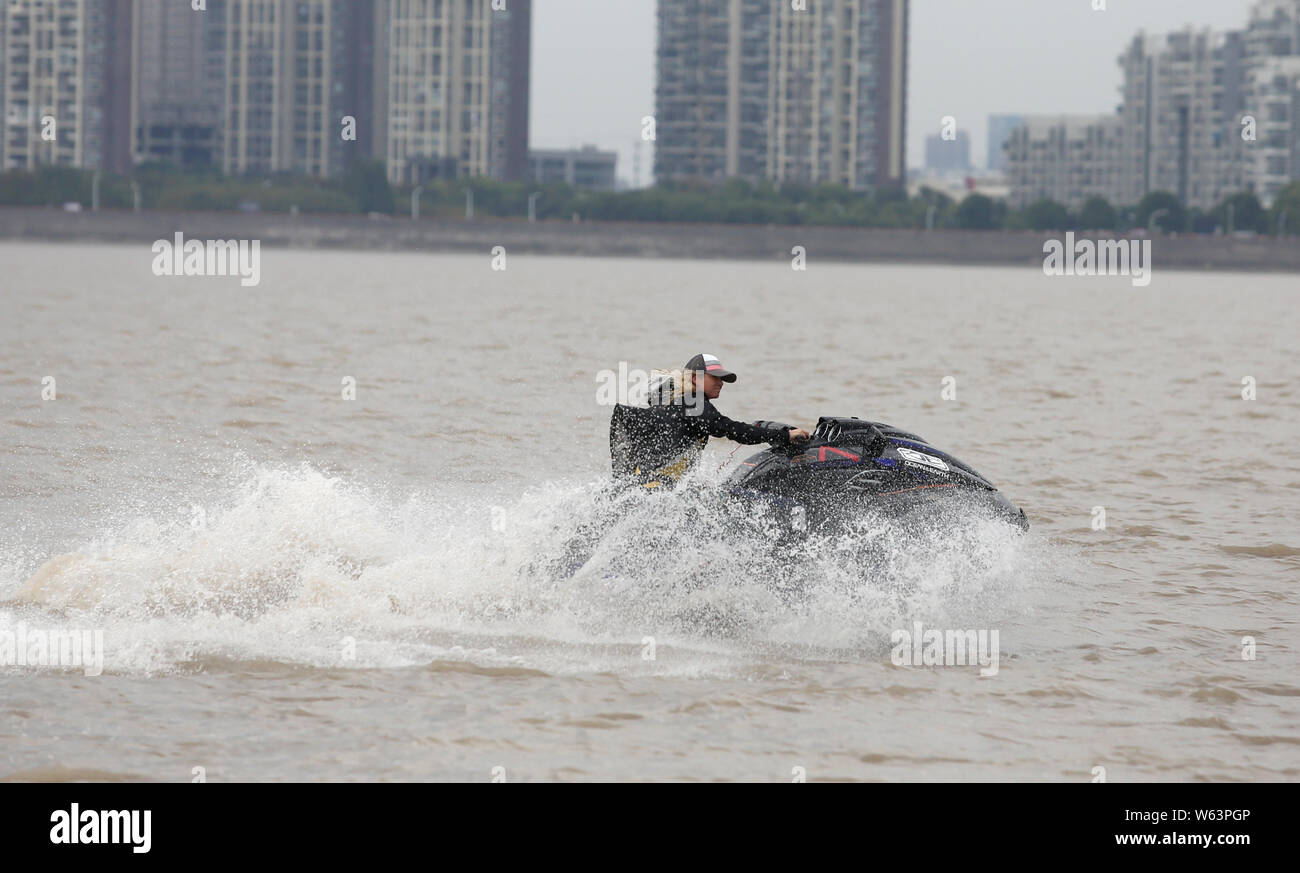 A participant takes a motorboat as she surfs a tidal bore of the ...
