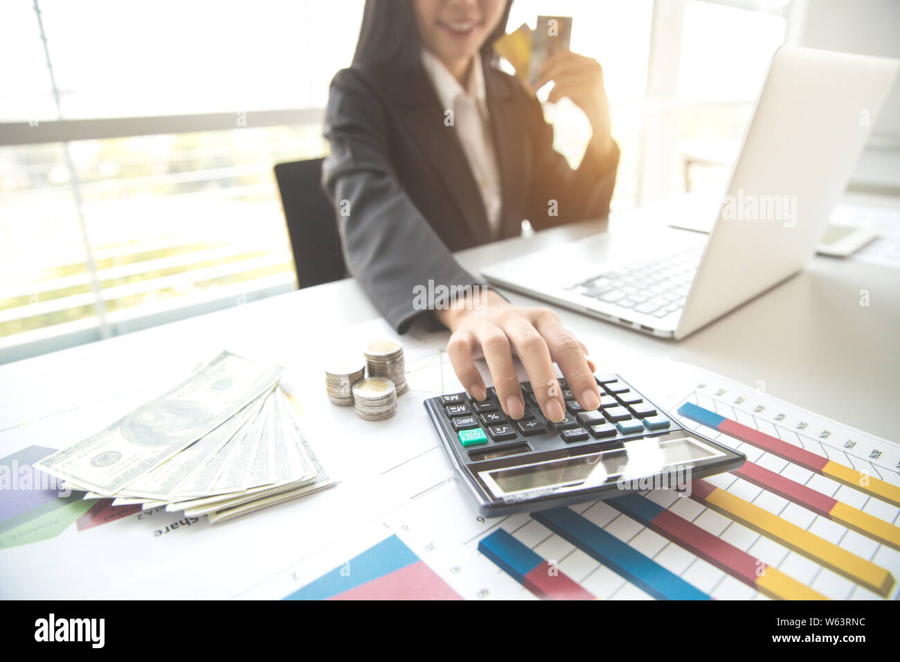 businesswoman using laptop computer while working on company summary ...