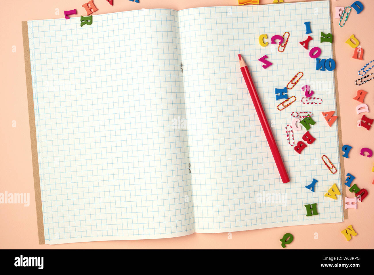 open checked notebook and red wooden pencil, back to school backdrop ...