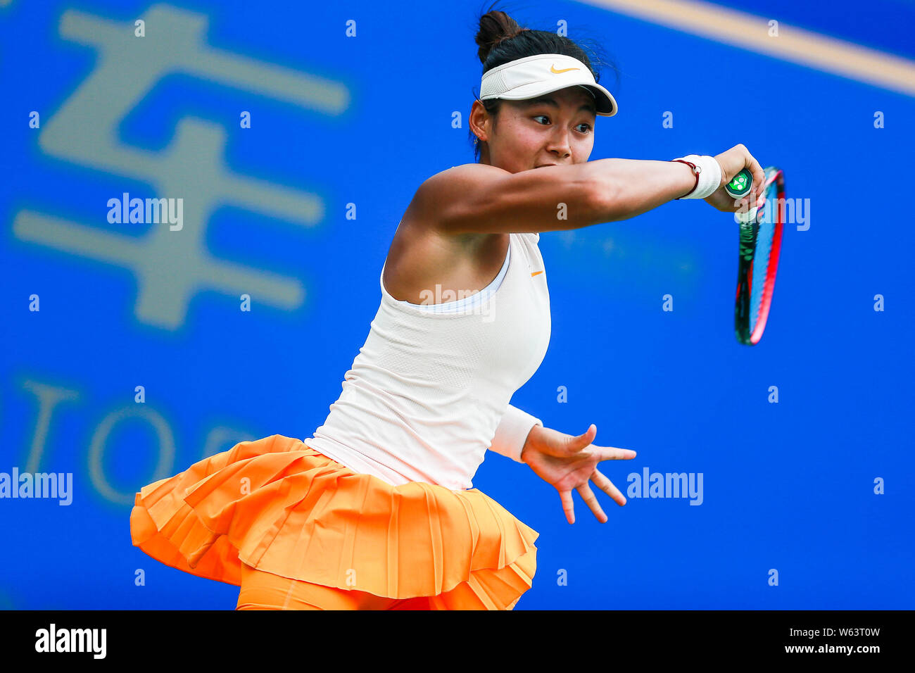 Wang Yafan of China returns a shot to Amanda Anisimova of United States ...
