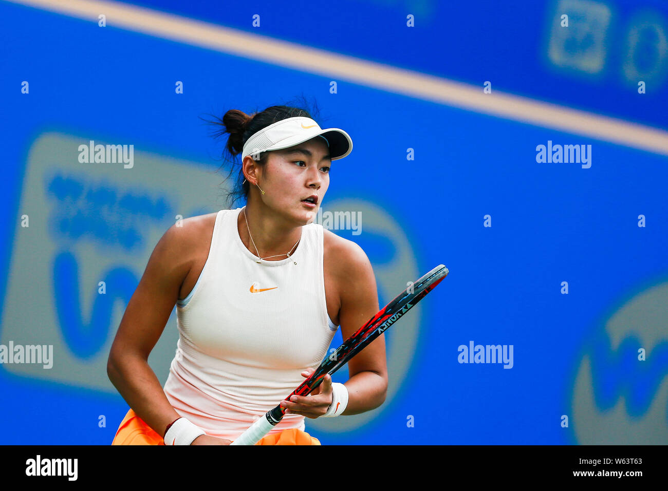 Wang Yafan of China returns a shot to Amanda Anisimova of United States ...