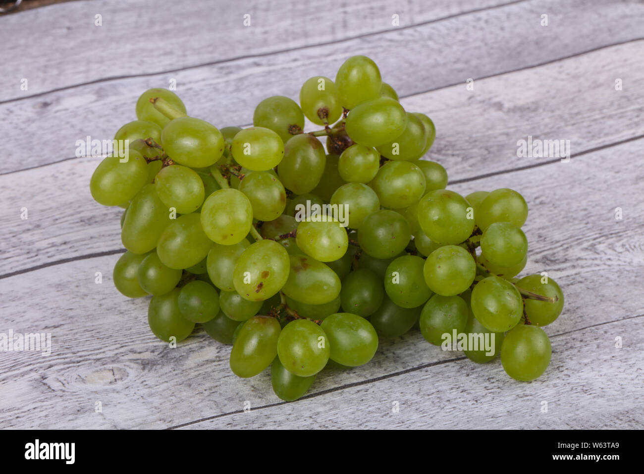 Sweet green grape branch over background Stock Photo - Alamy