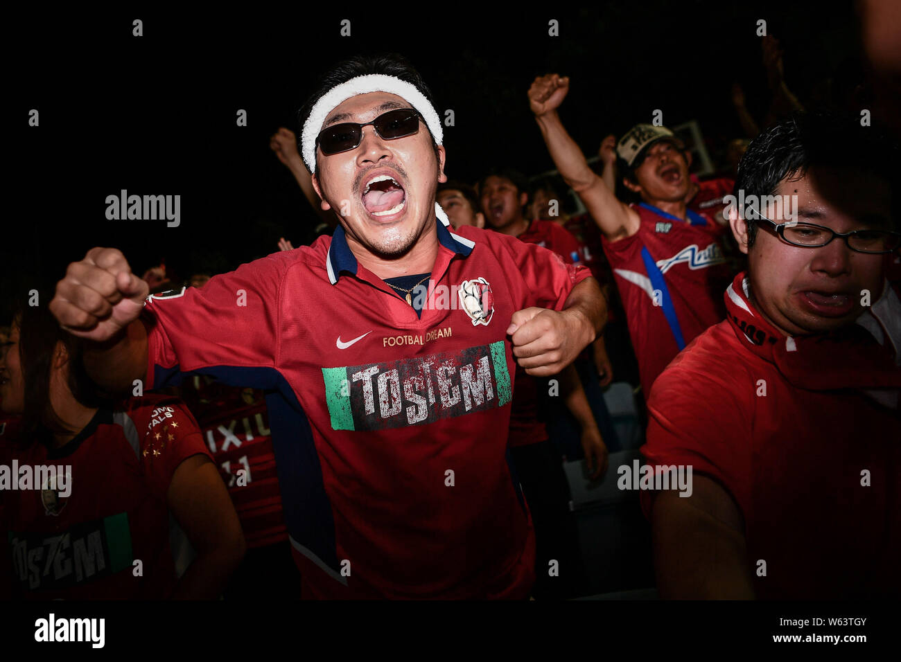 Football fans wave flags and shout slogans to show support for Japan's ...