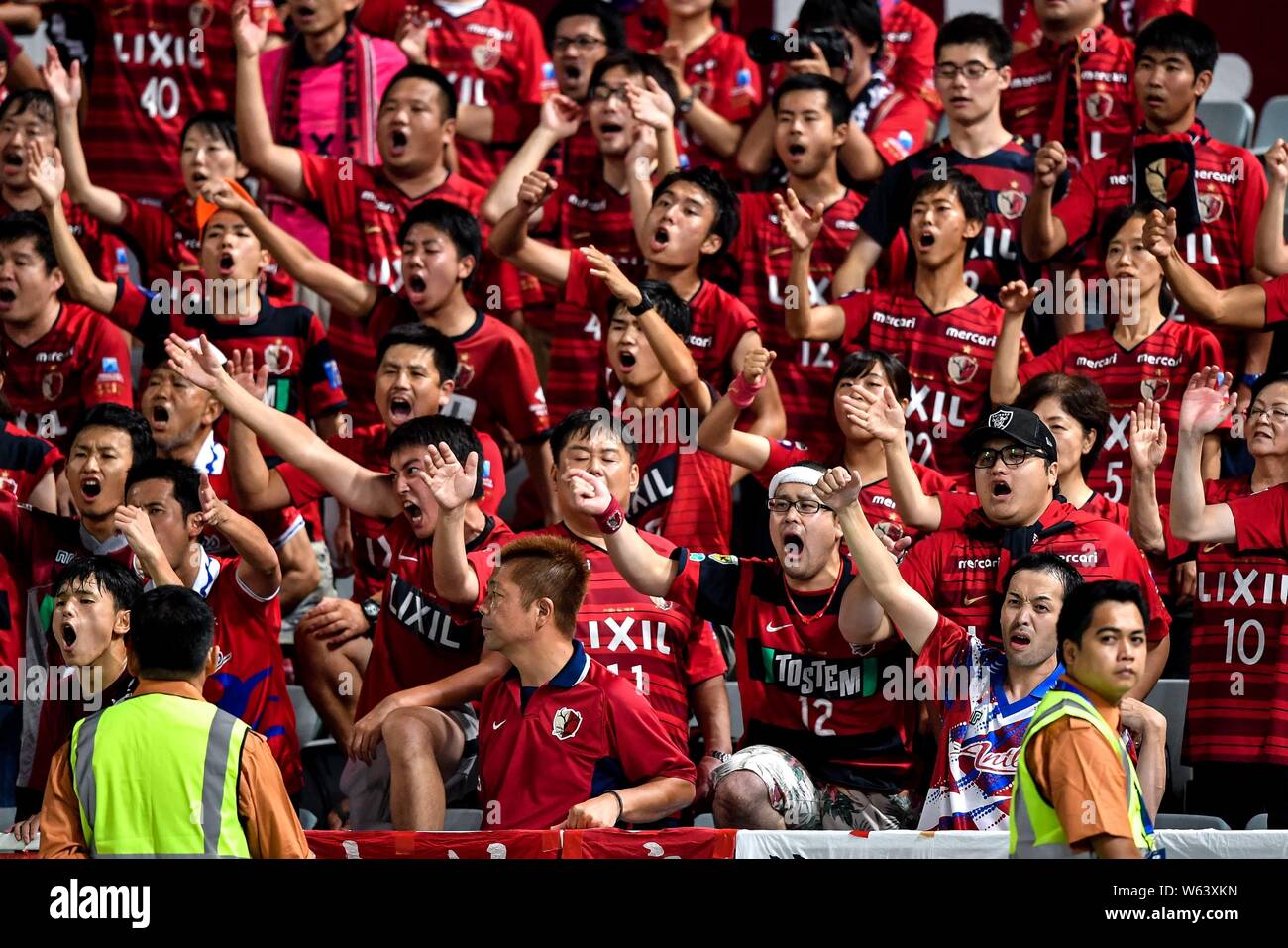 Football fans wave flags and shout slogans to show support for Japan's Kashima Antlers in the ...