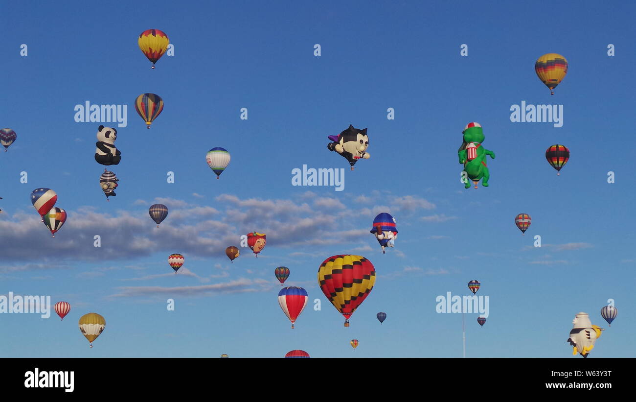 Colorful and assorted styles of hot air balloons hovering against blue ...