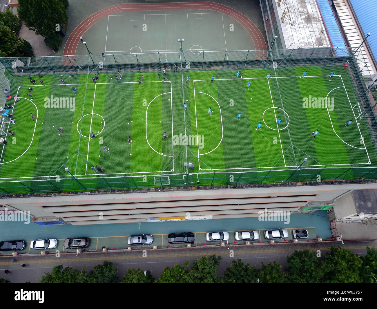 In this aerial view, children play football at a football stadium built ...