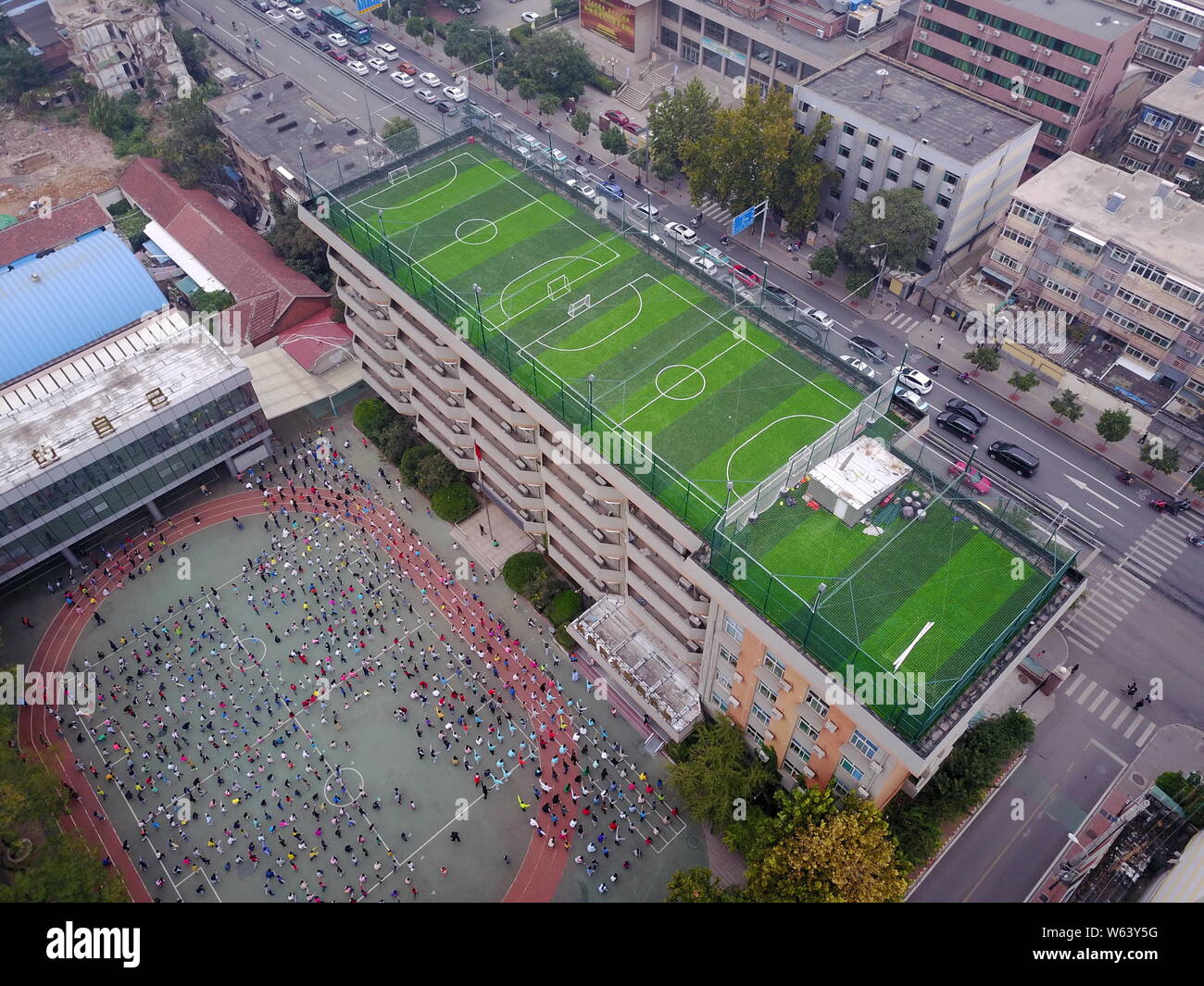 In this aerial view, children play football at a football stadium built ...