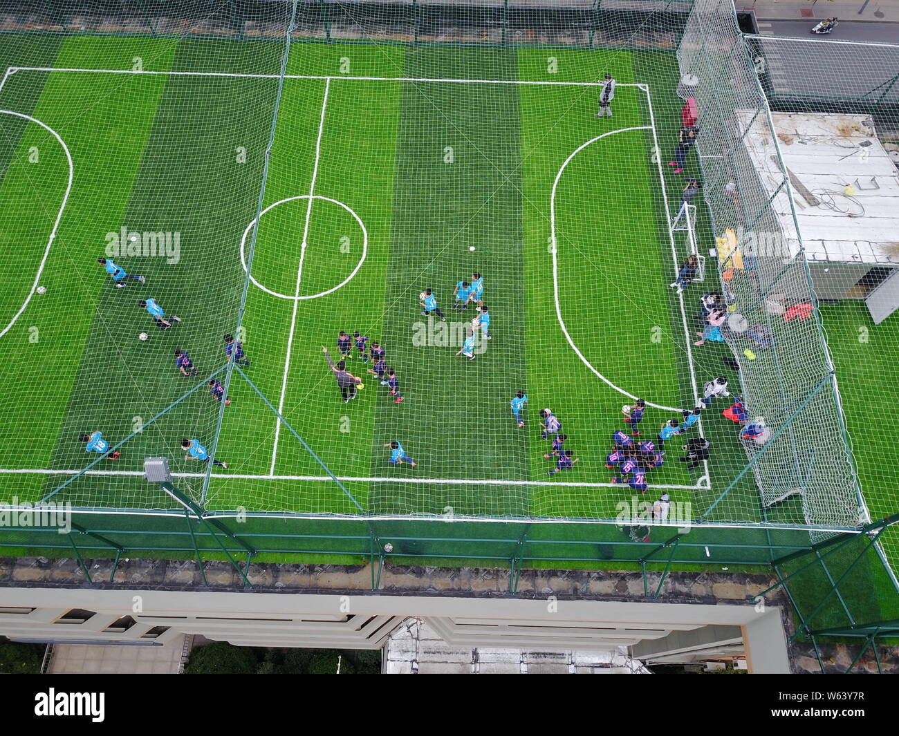 In this aerial view, children play football at a football stadium built ...