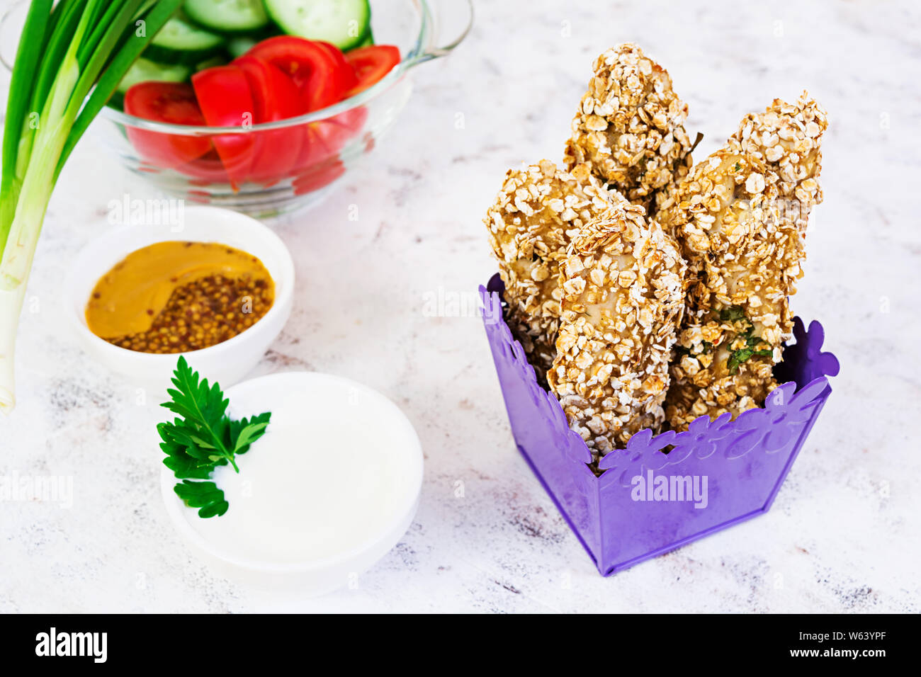Chicken fillet in oat flakes on white background Stock Photo - Alamy