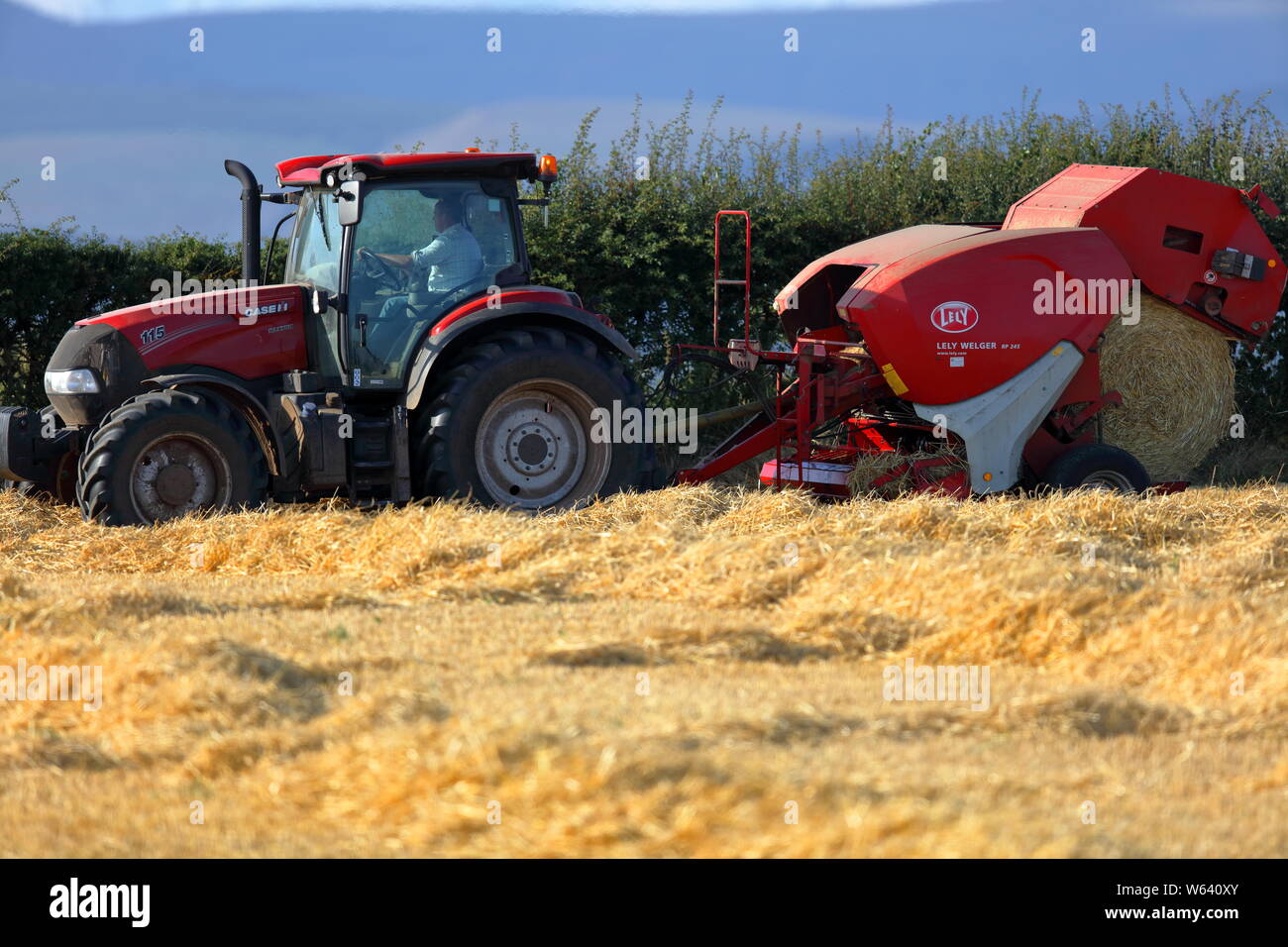 A modern straw compactor collecting the straw and rolling it into huge ...