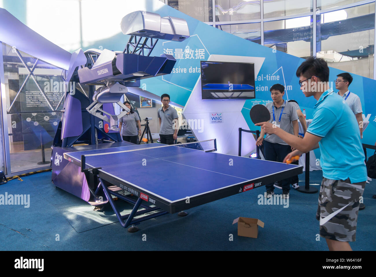 A visitor plays table tennis with a Ping-pong robot Pongbot developed ...
