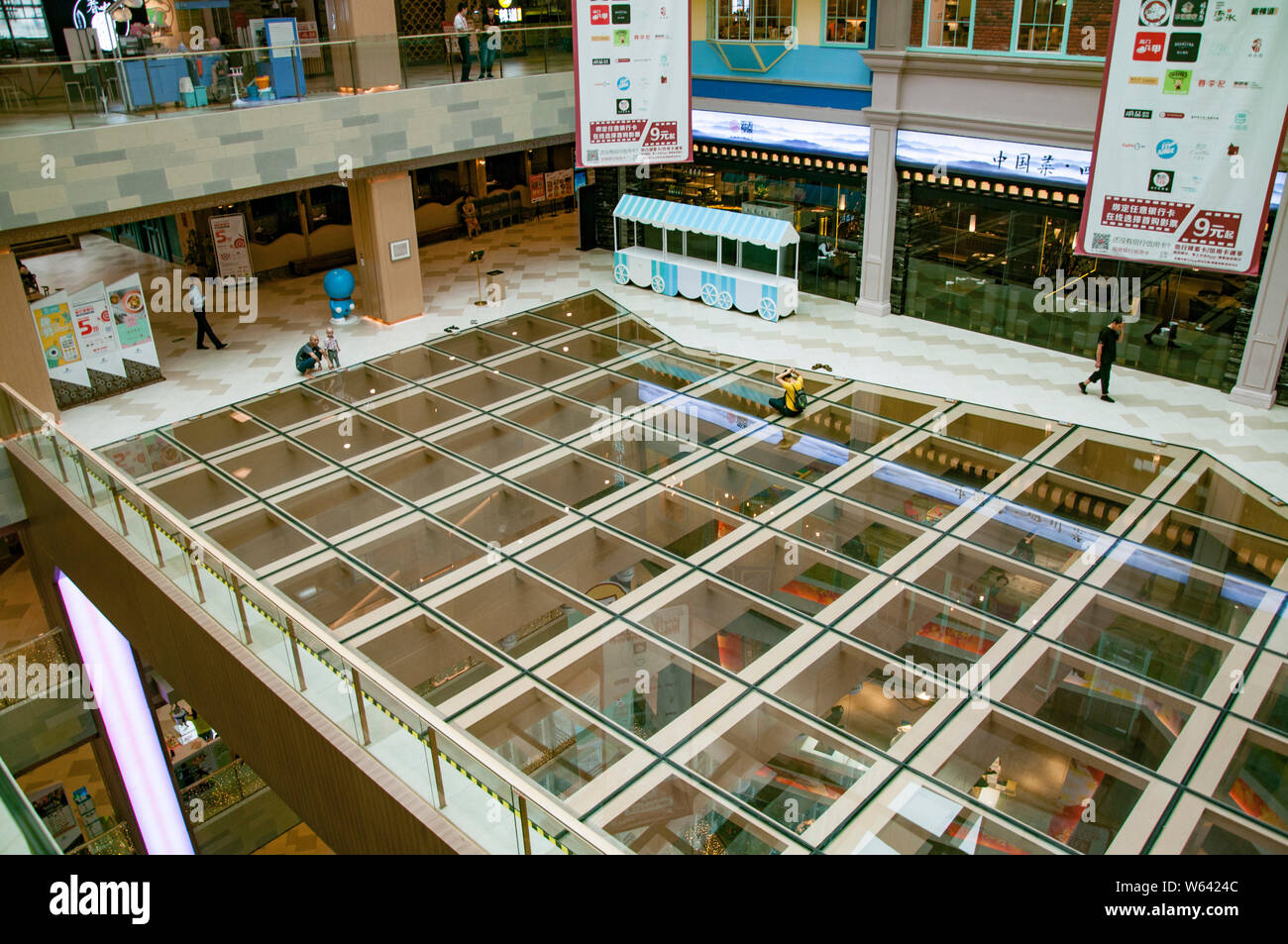 Customers walk on the 5-storey-high glass-bottomed viewing platform at ...