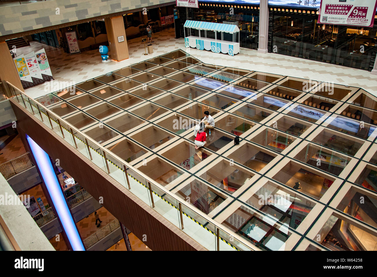 Customers walk on the 5-storey-high glass-bottomed viewing platform at ...