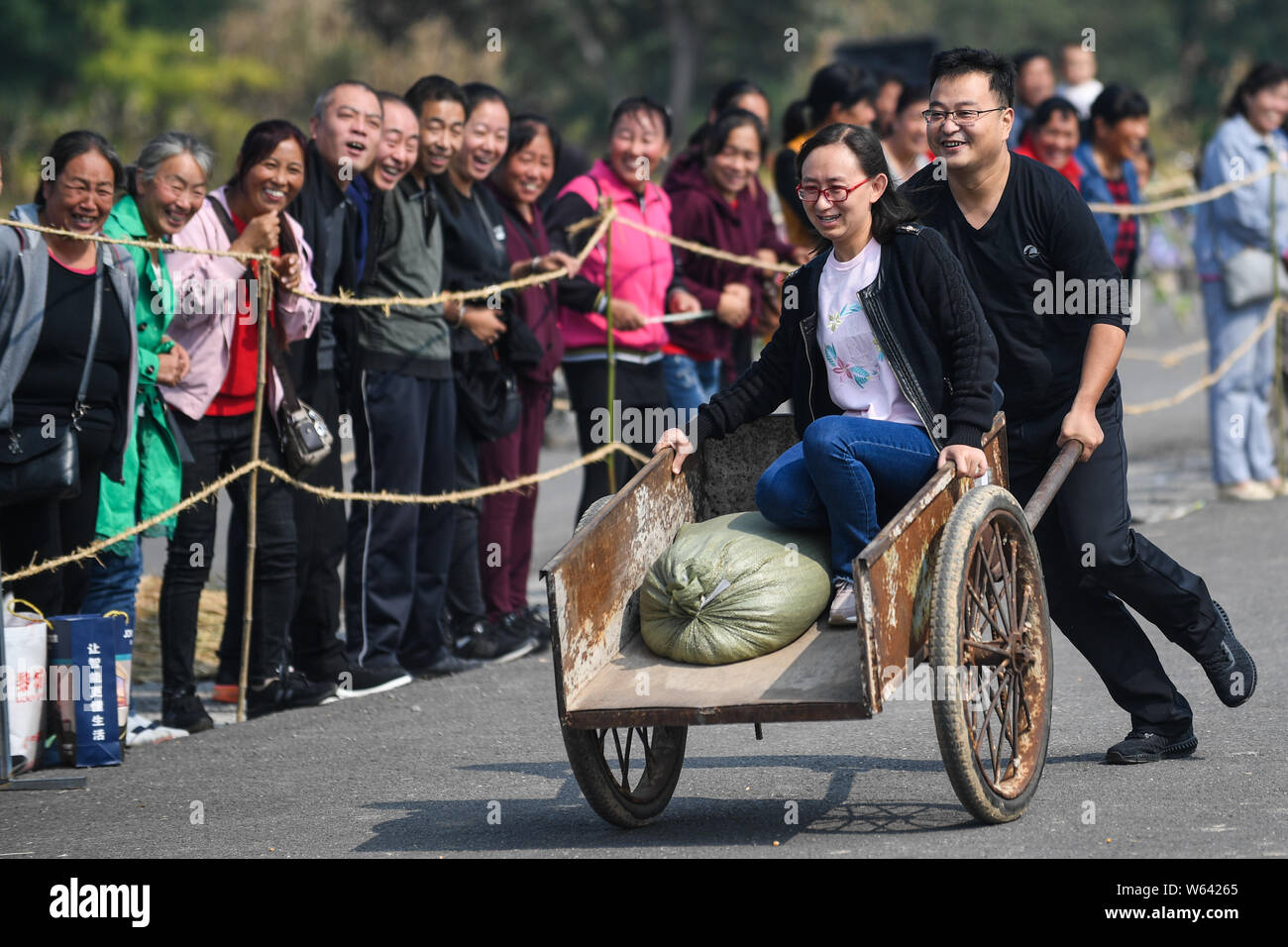 A Chinese farmer carts his wife and stuffed sack in the wife-carting ...