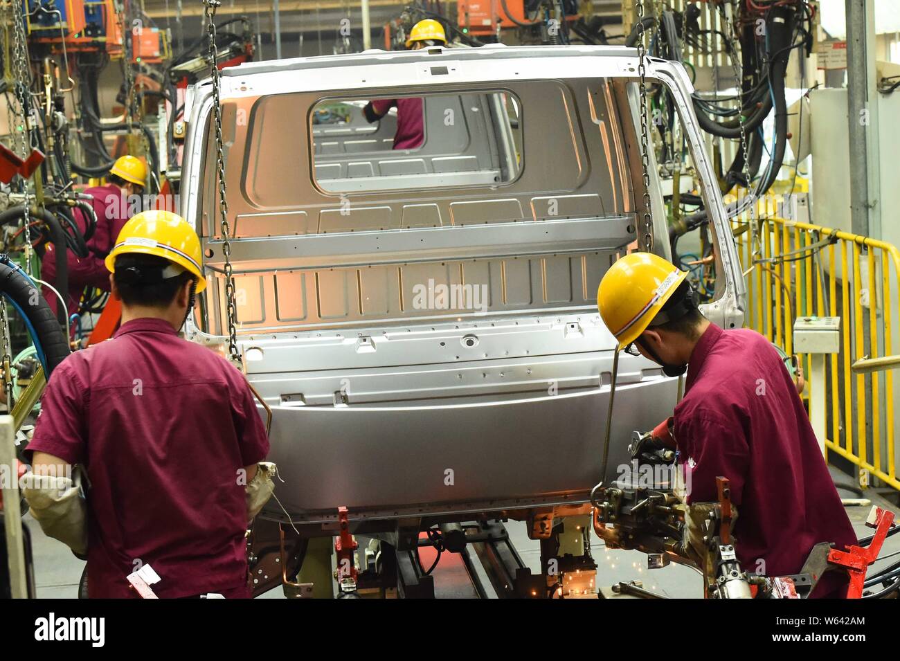 --FILE--Chinese workers assemble a truck on the assembly line at the ...