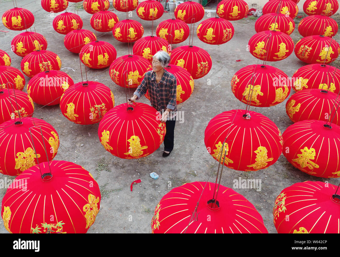 Chinese workers make red lanterns for the upcoming National Day at a ...