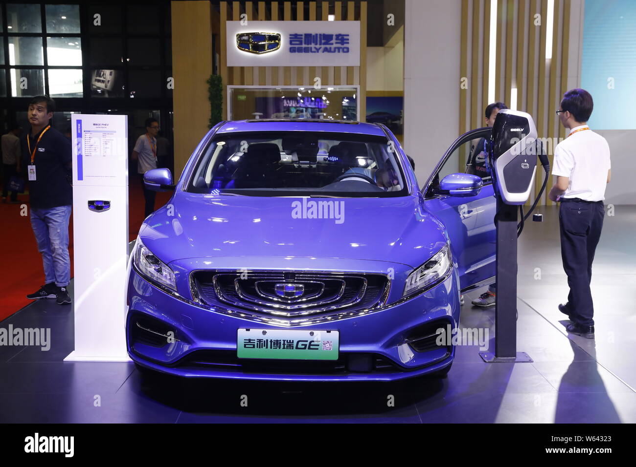 Chinese visitors view or try out a Geely Emgrand GE hybrid car on ...