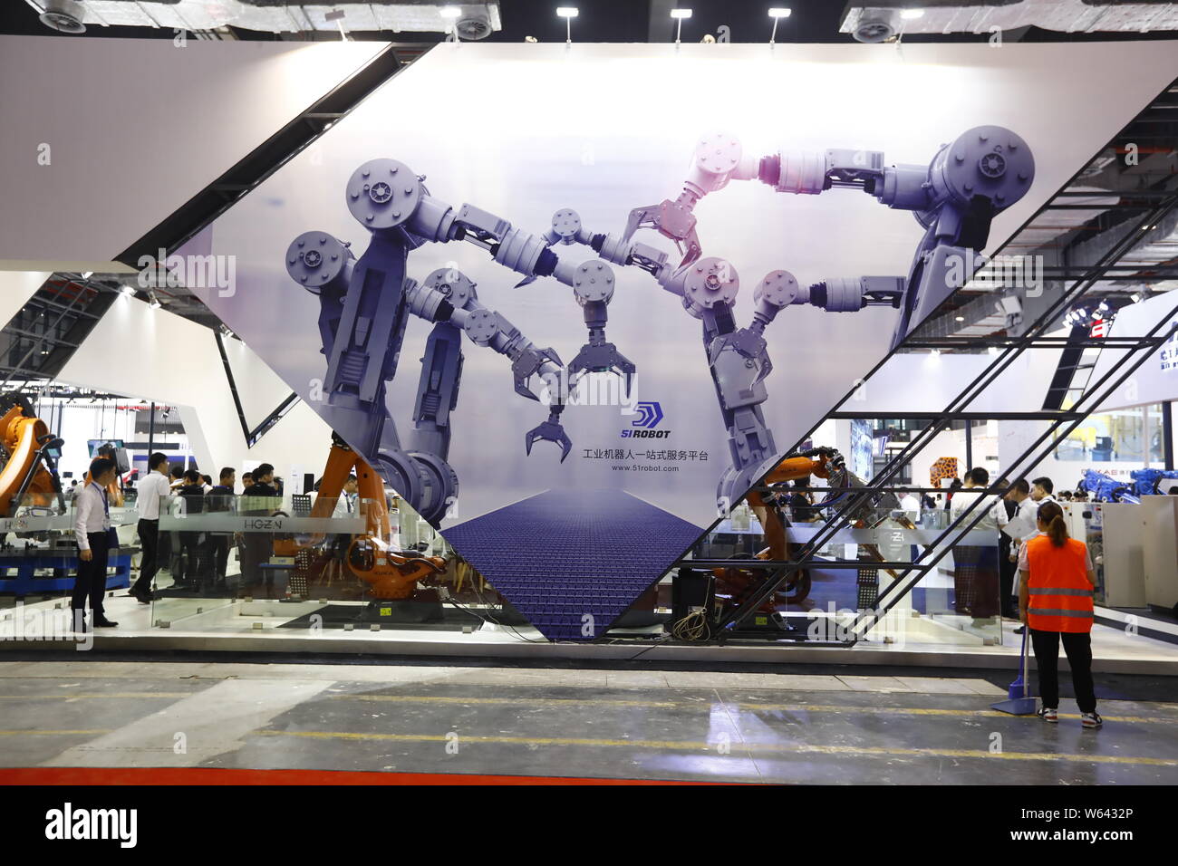 A Chinese cleaner works in front of a giant billboard of Chinese ...