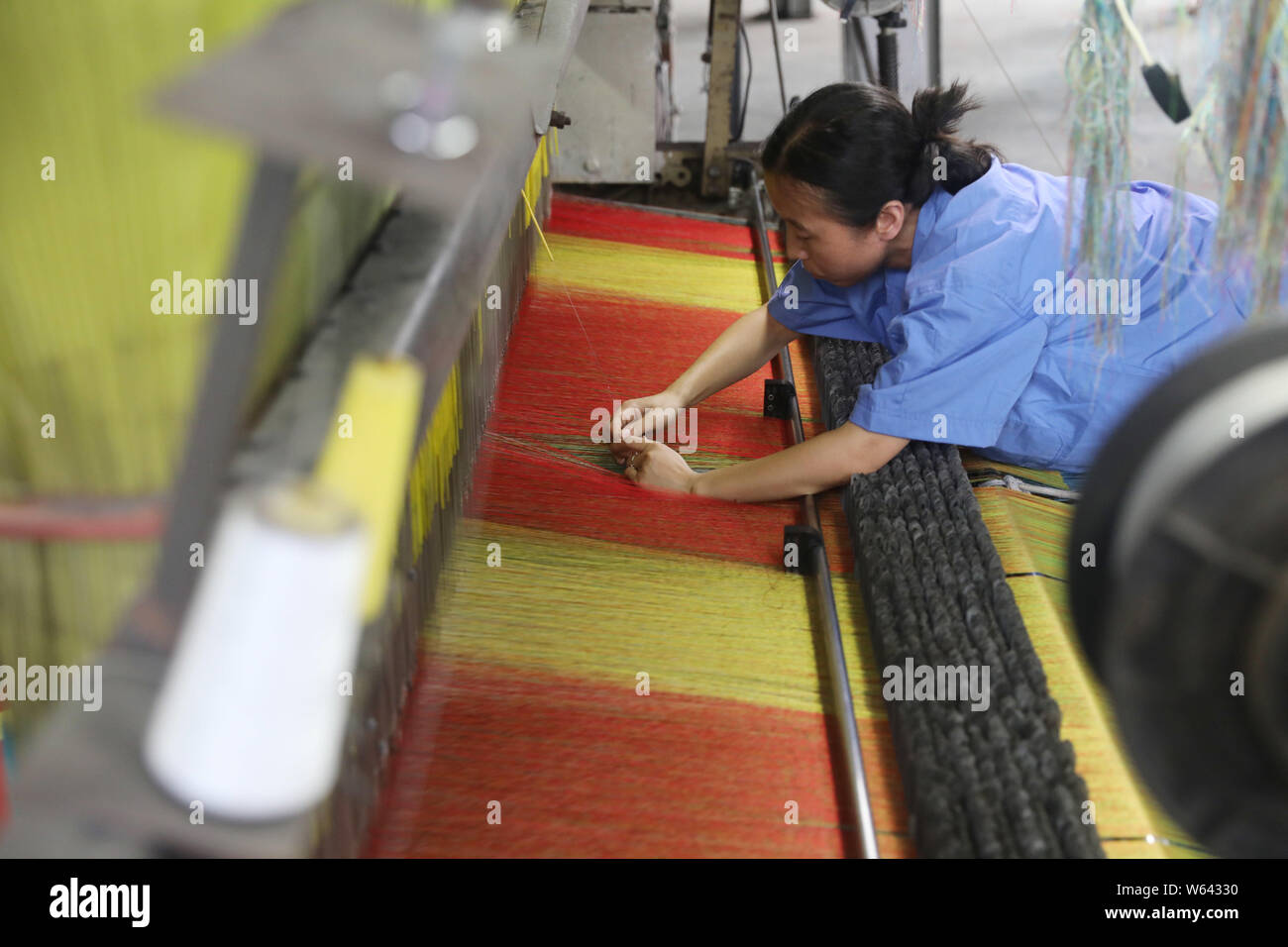 --FILE--A female Chinese worker handles production of yarn at a textile factory in Hangzhou city ...