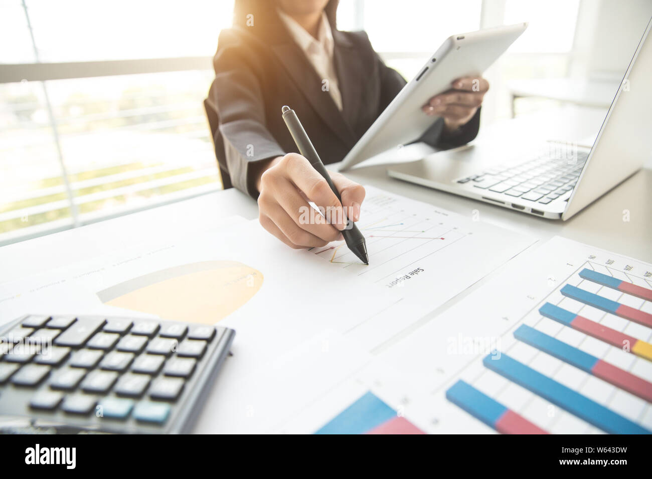 businesswoman using tablet and laptop computer while working on company ...