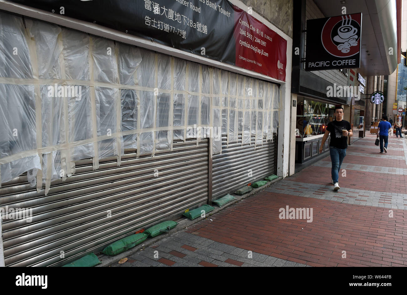 Windows of a building are taped up in preparation for the Typhoon ...