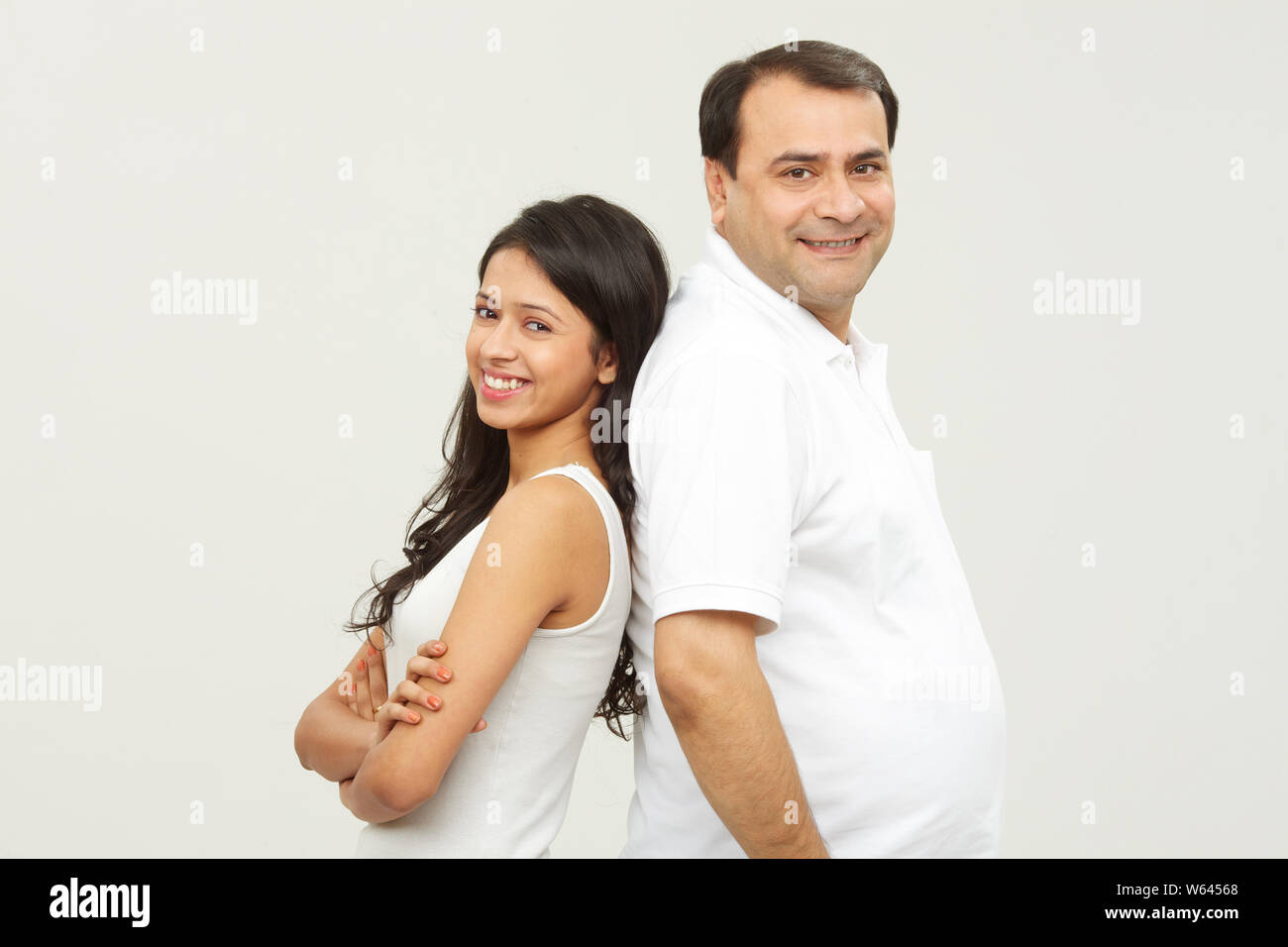 Man with his daughter smiling back to back Stock Photo - Alamy