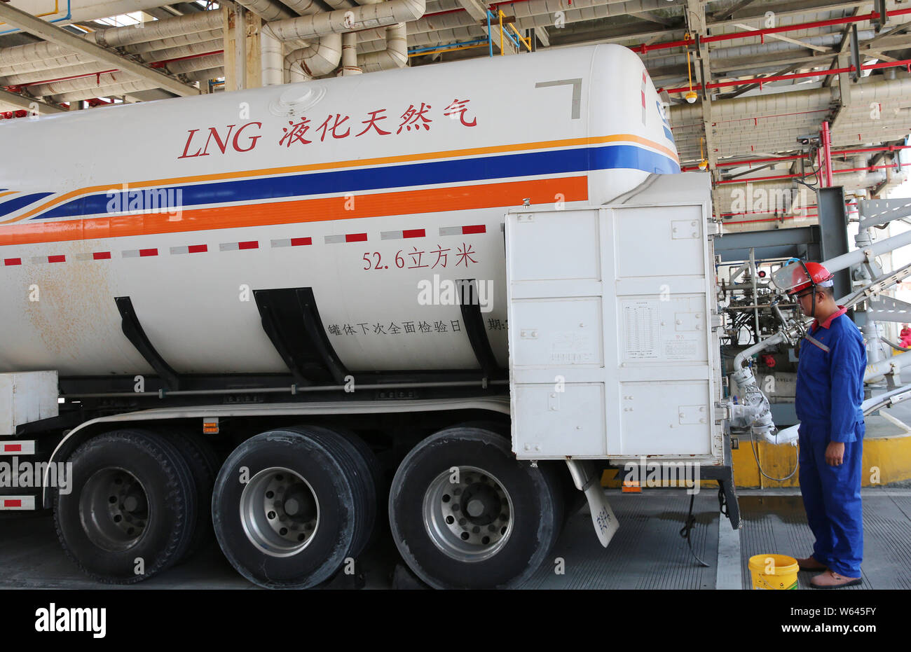 Chinese workers load a tanker with liquefied natural gas (LNG) at the ...
