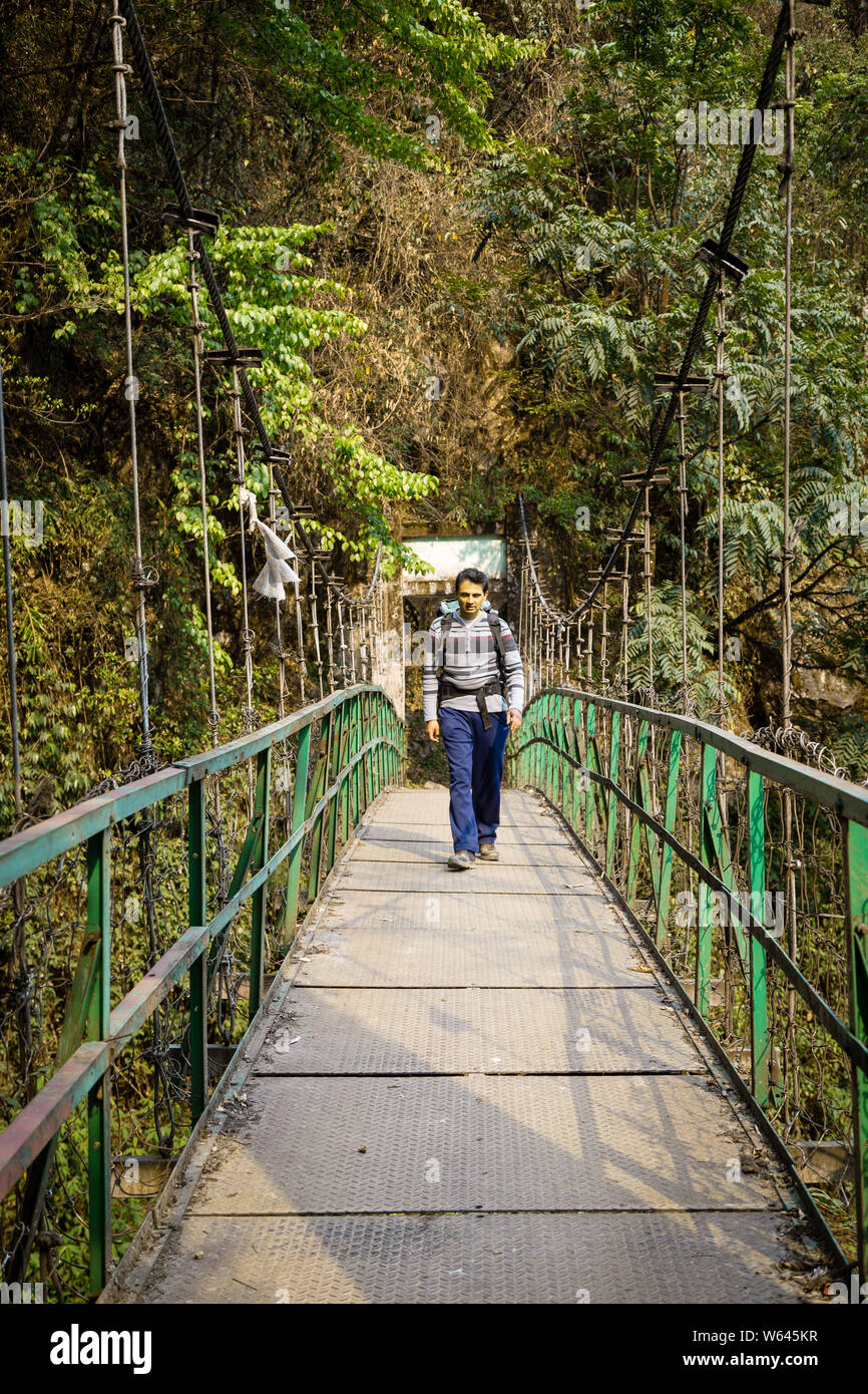 A man crosses a bridge on the Gochela trekking trail to the ...