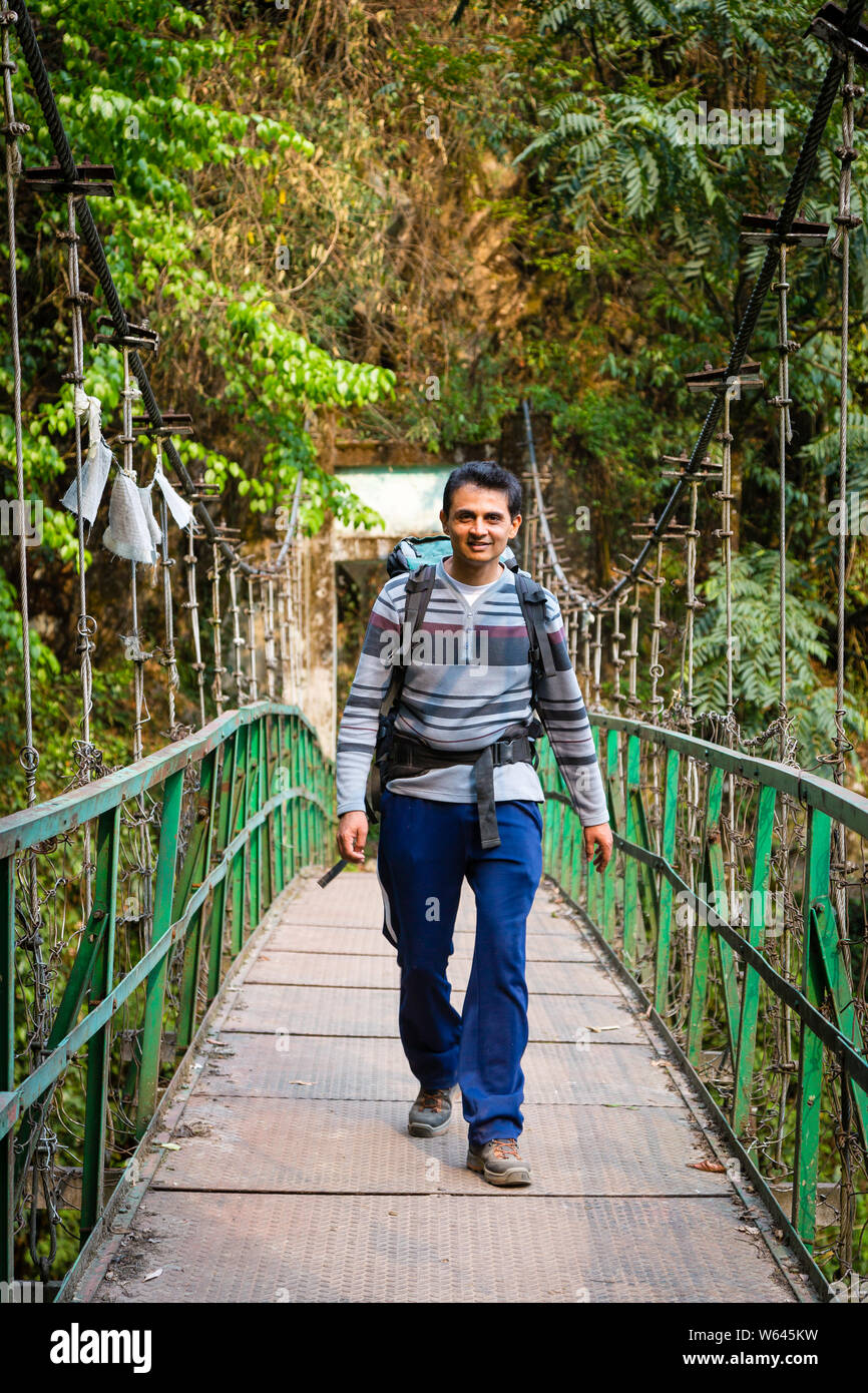 A man crosses a bridge on the Gochela trekking trail to the ...