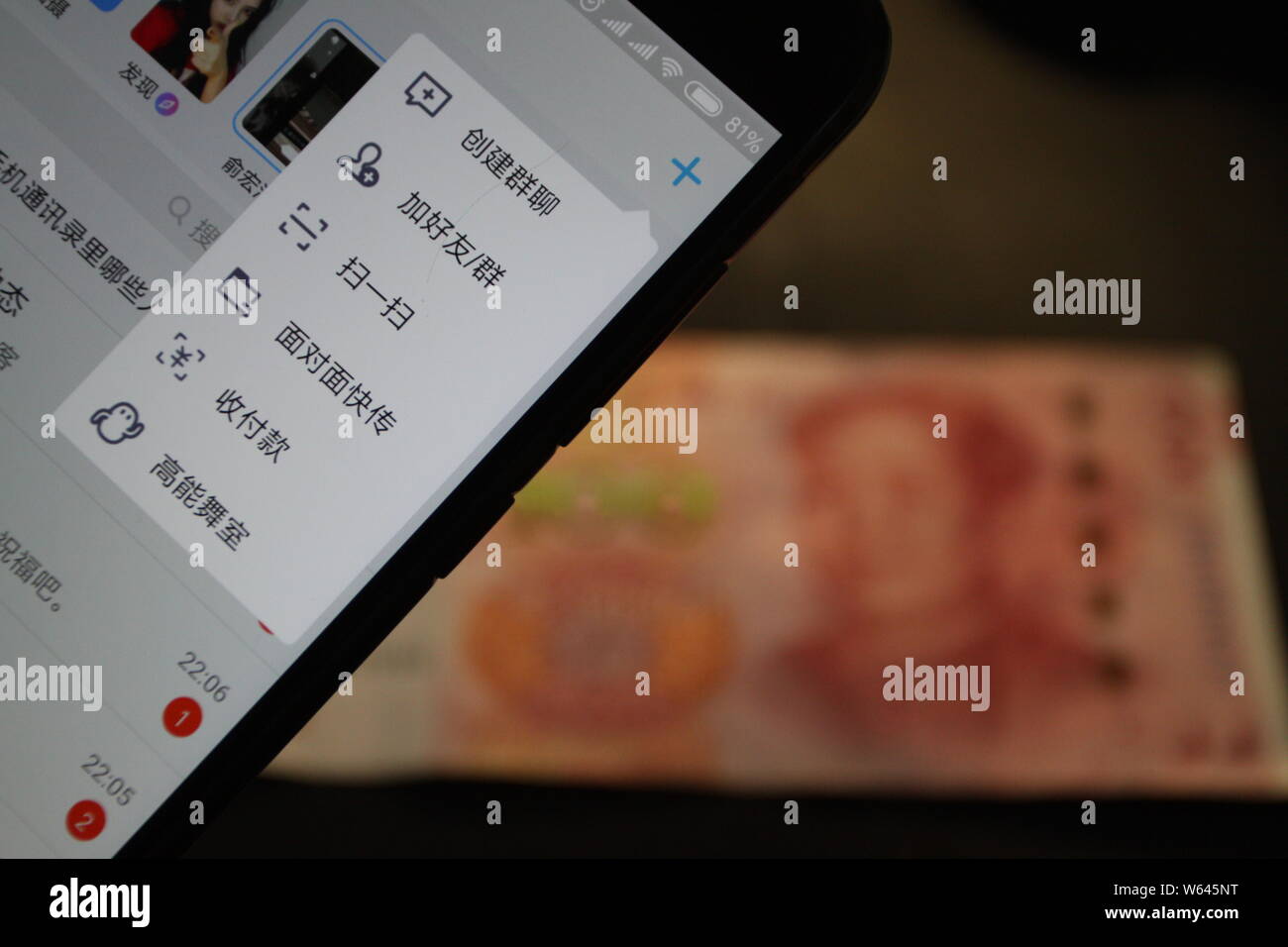 A Chinese mobile phone user scans a 100-yuan RMB (renminbi) banknote ...