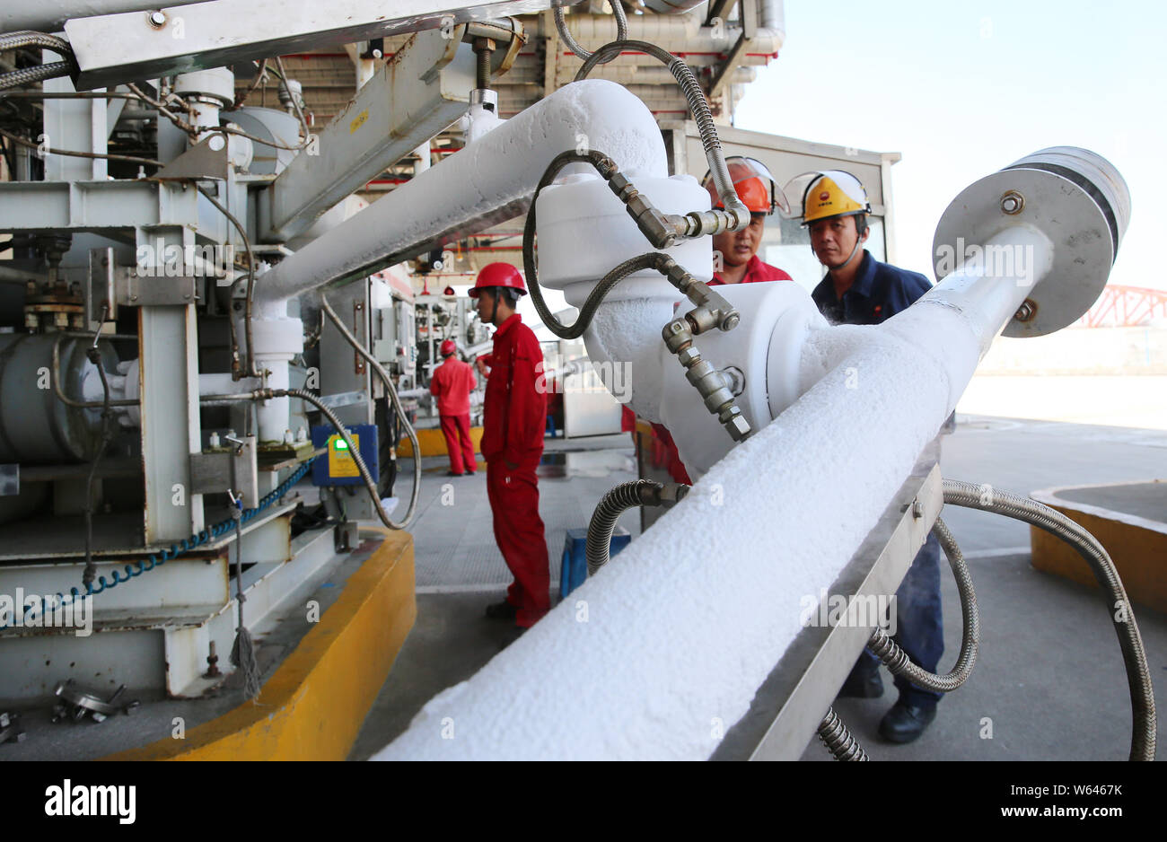 Chinese workers load a tanker with liquefied natural gas (LNG) at the ...