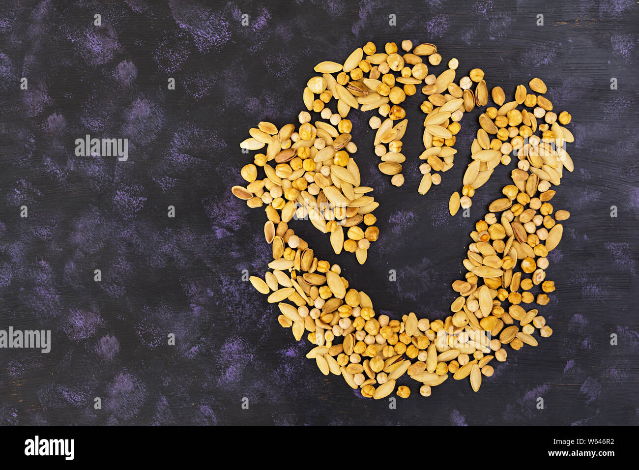 Different kinds of nuts on dark background Stock Photo - Alamy