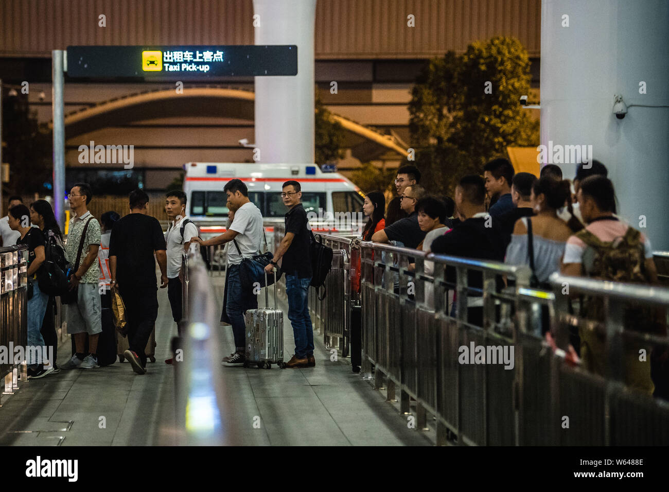Passengers wait in a long queue at the taxi pick-up stand at the ...