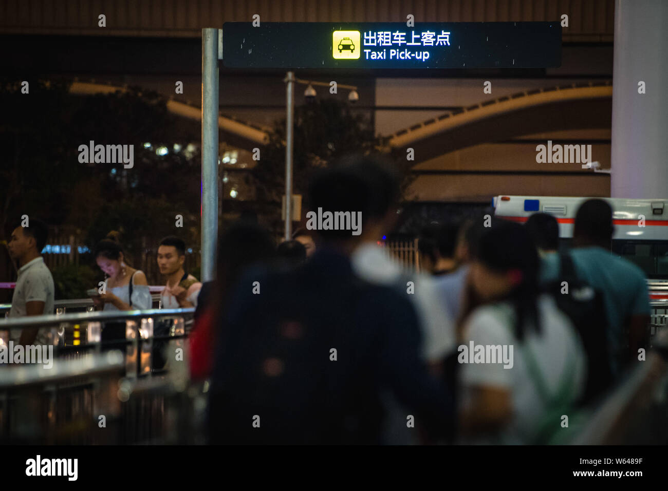 Passengers wait in a long queue at the taxi pick-up stand at the ...