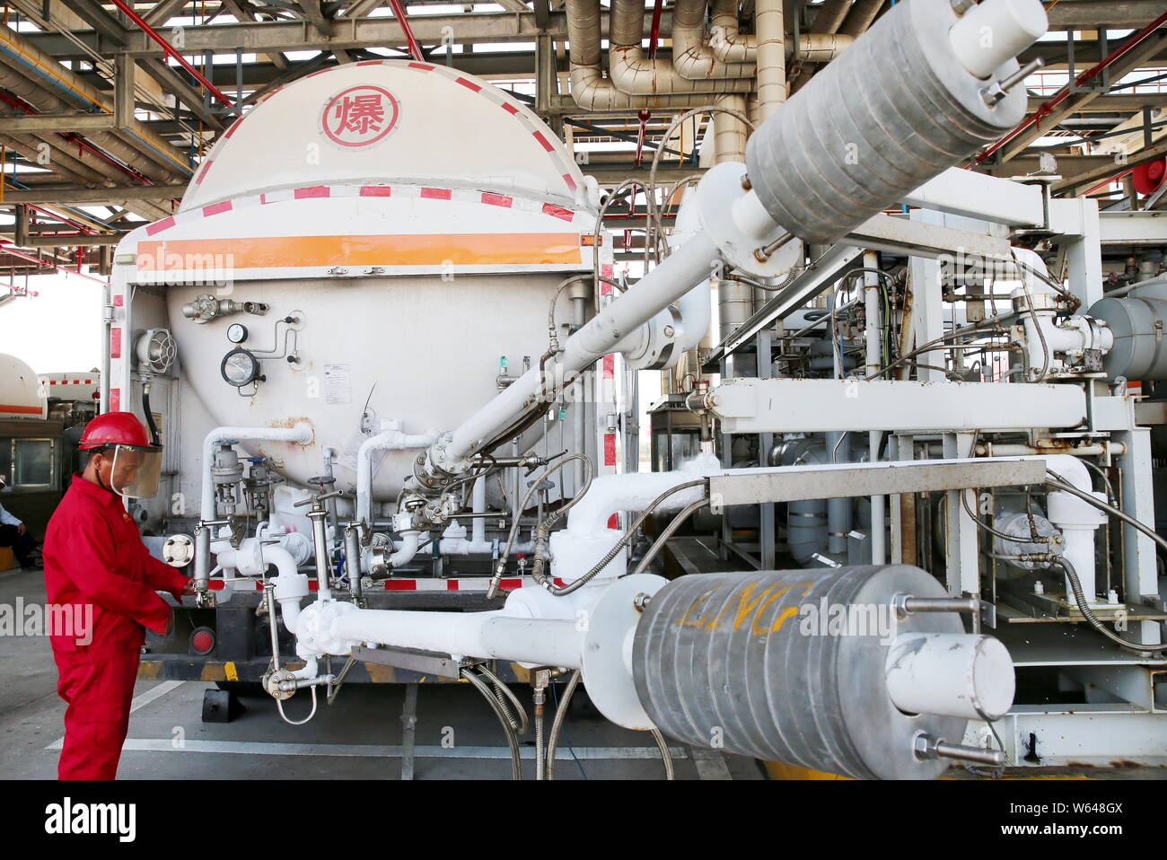 Chinese workers load a tanker with liquefied natural gas (LNG) at the ...
