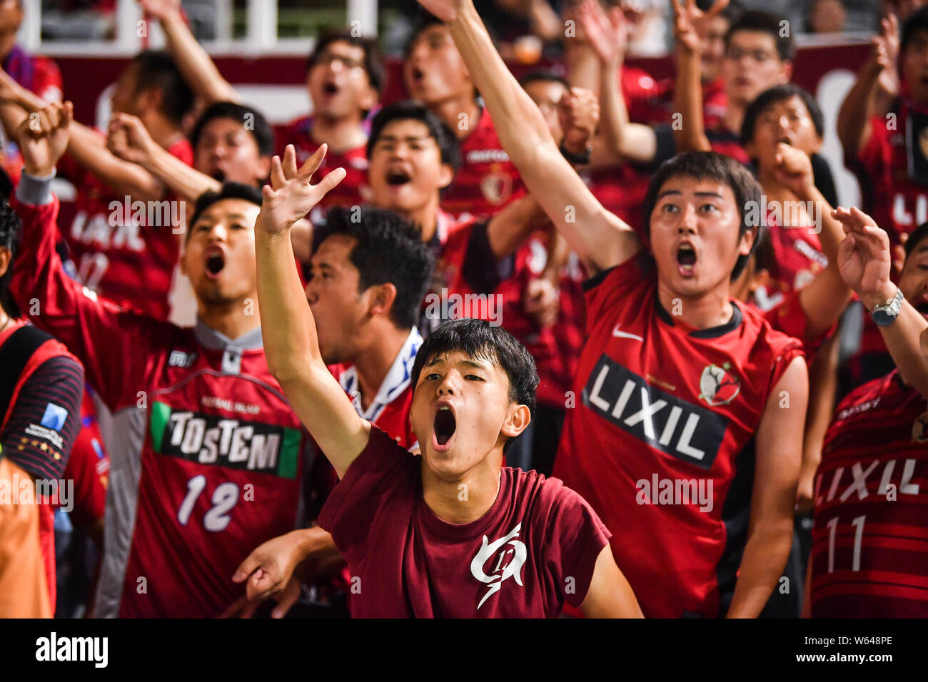 Football fans wave flags and shout slogans to show support for Japan's Kashima Antlers in the ...