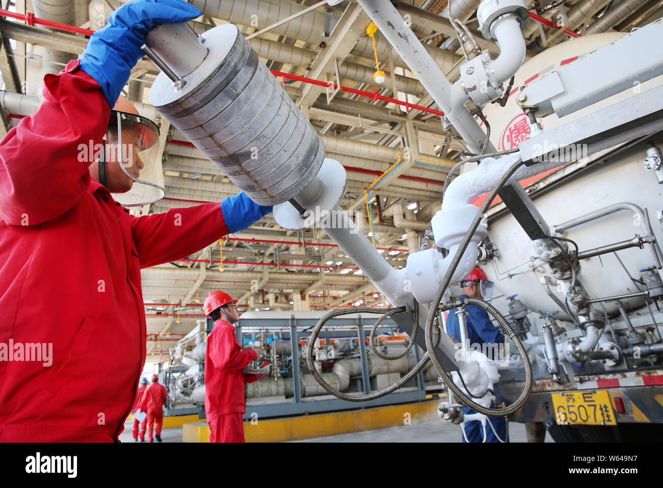 Chinese workers load a tanker with liquefied natural gas (LNG) at the ...
